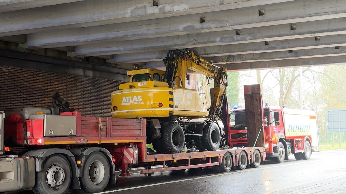 Vrachtwagen met kraan rijdt zicht vast onder brug op grens tussen ...