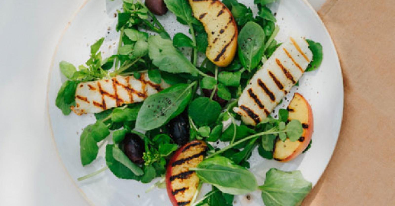 Salade van gegrilde perzik, basilicum, halloumi en zwarte olijven